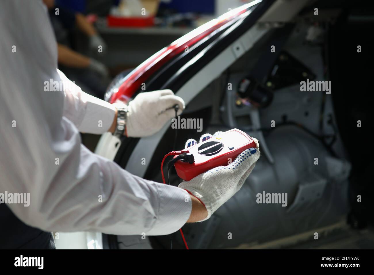 Mechanics hand using multimeter to measure voltage of car battery Stock ...