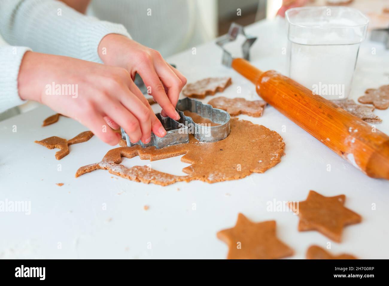 Kid's hands making gingerbread, cutting cookies of gingerbread dough. Christmas bakery. Friends ...