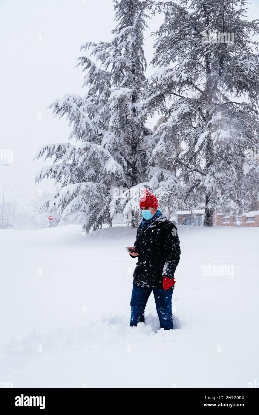 People walking on city street covered in snow during heavy snowfall ...