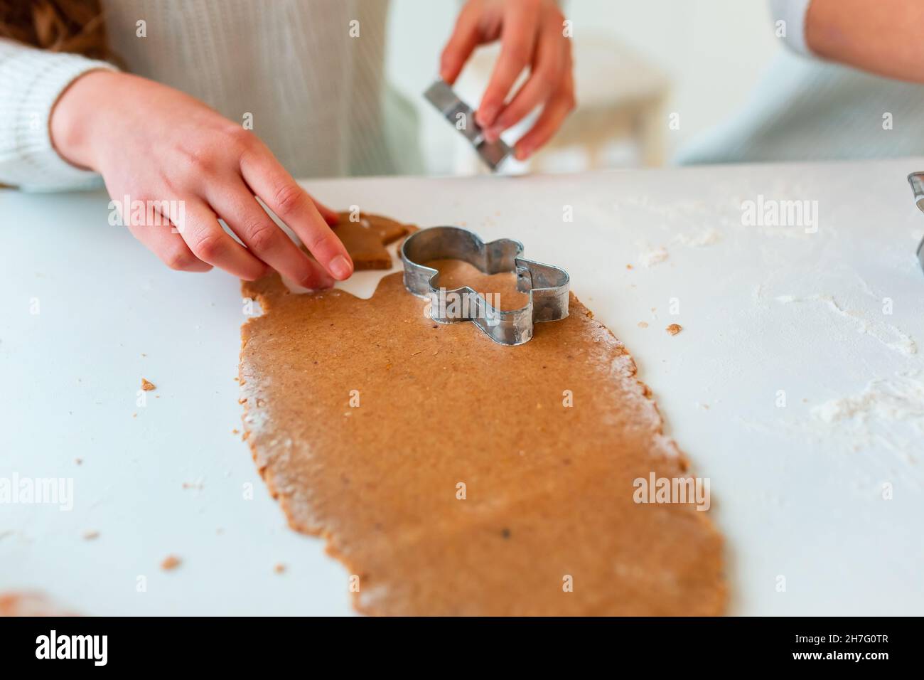 Kid's hands making gingerbread, cutting cookies of gingerbread dough ...