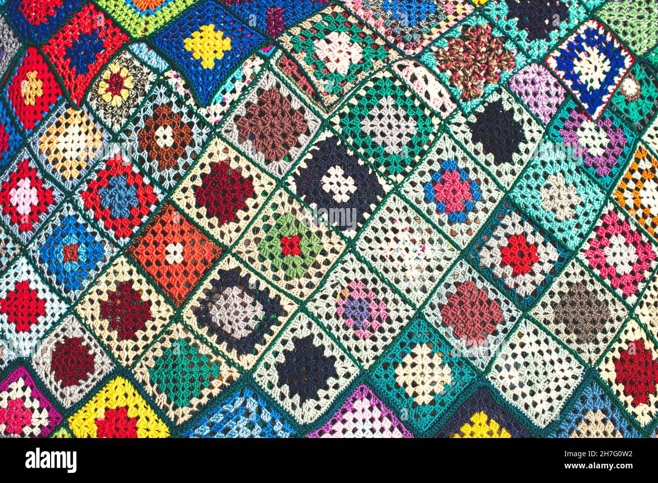 Crocheted wool blanket with colorful checks Stock Photo - Alamy