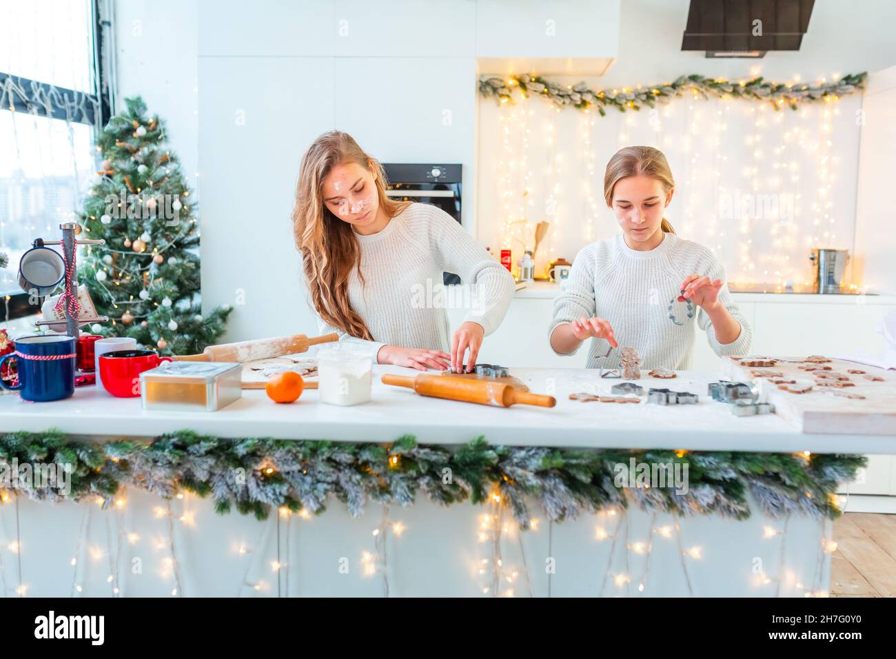 Two happy girls cooking making gingerbread, cutting cookies of ...