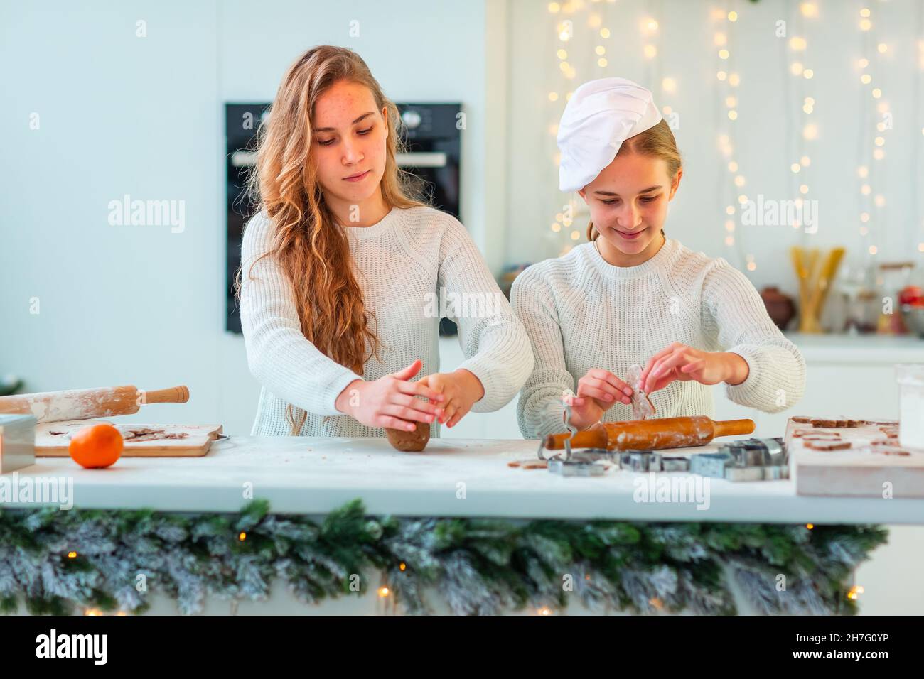 Two happy girls cooking making gingerbread, cutting cookies of ...