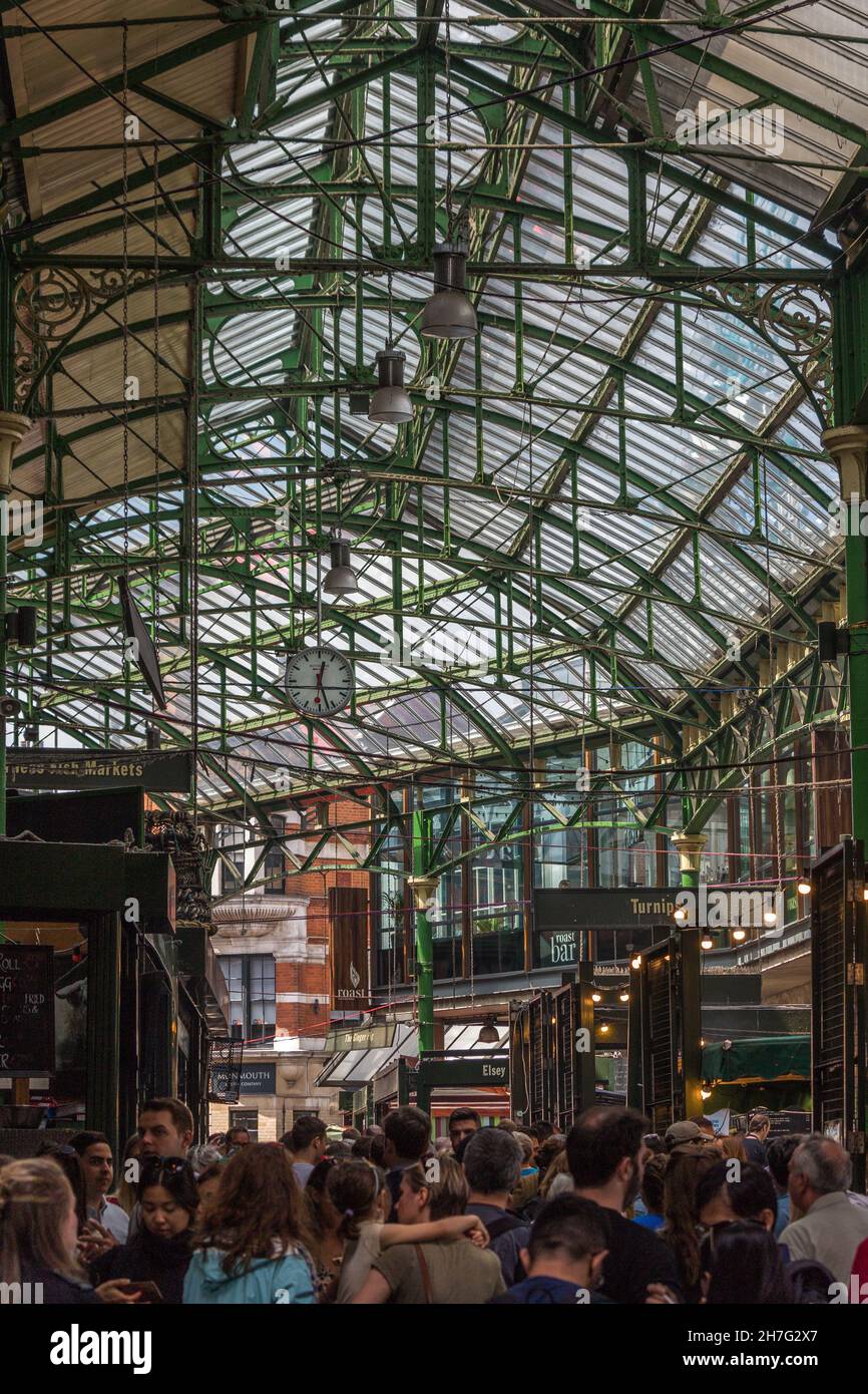 People shopping inside Borough Market, with iconic glass roof and clock ...