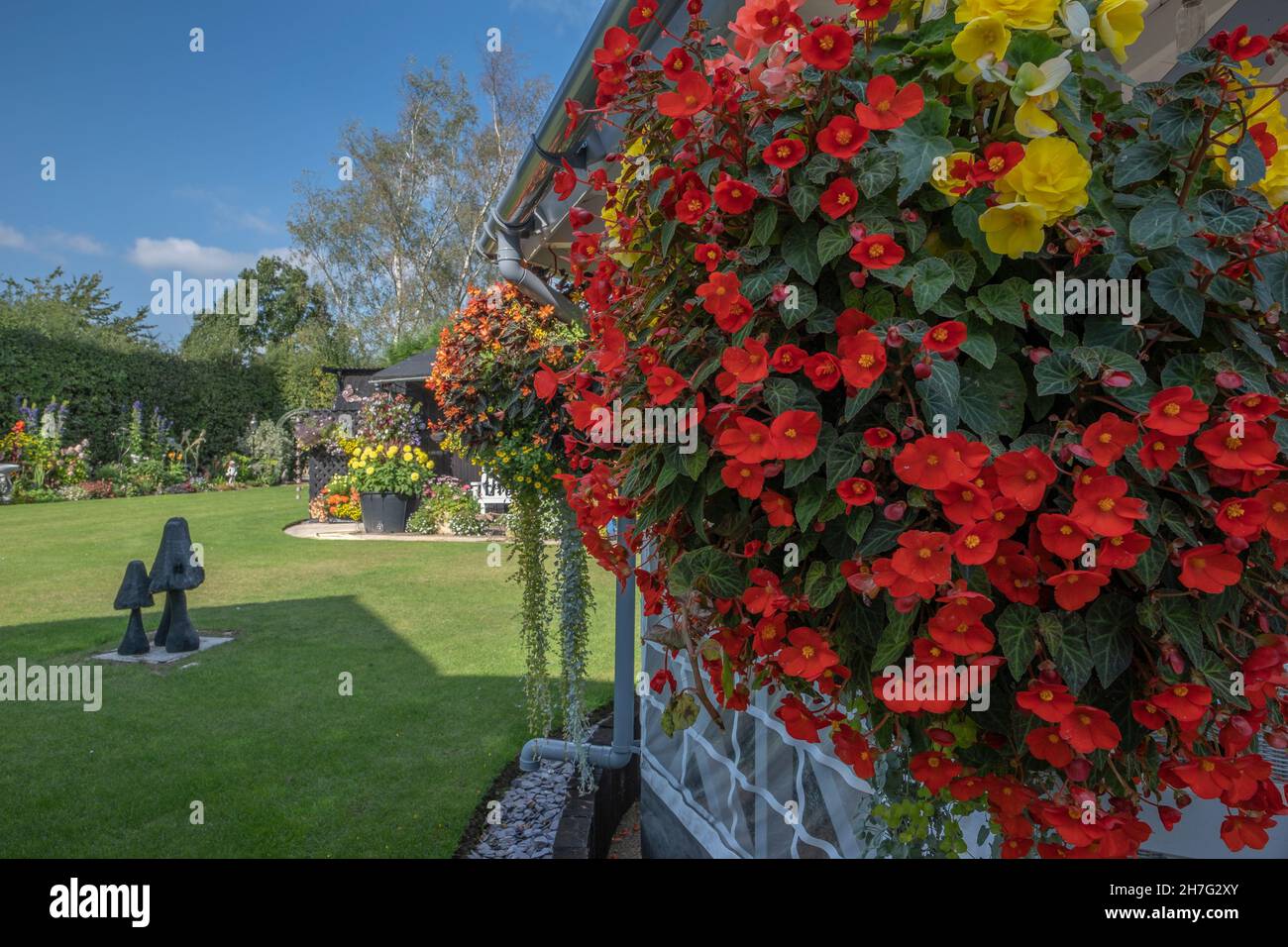 Beautiful flower tubs and baskets in a garden Stock Photo - Alamy