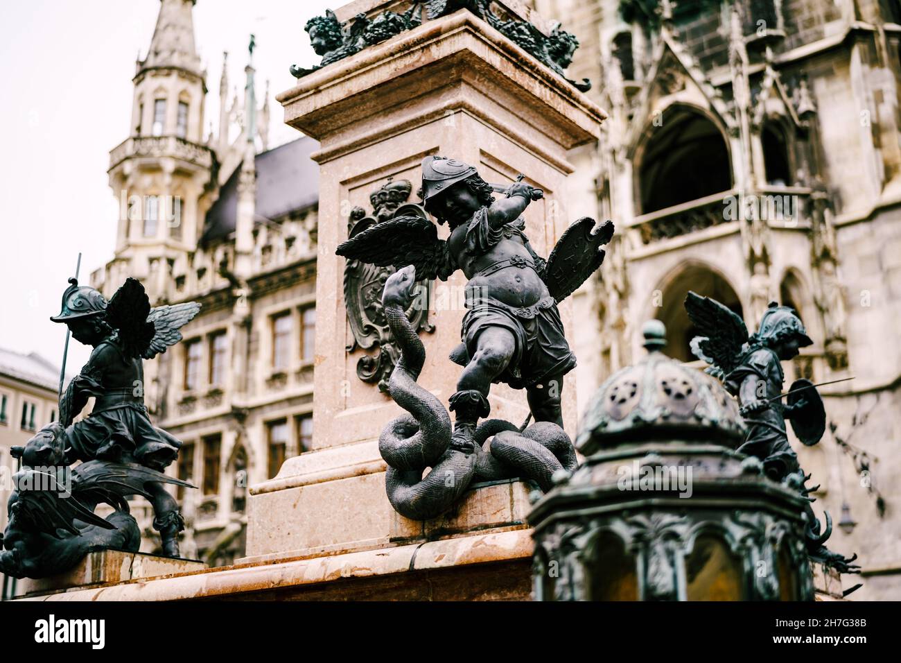 Angel defeating a dragon at a column. Statue at Marienplatz in Munich ...
