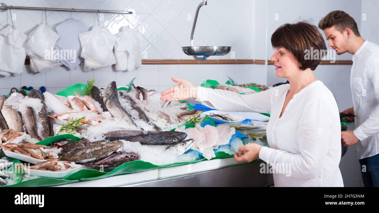 Positive female customer buying fish Stock Photo - Alamy