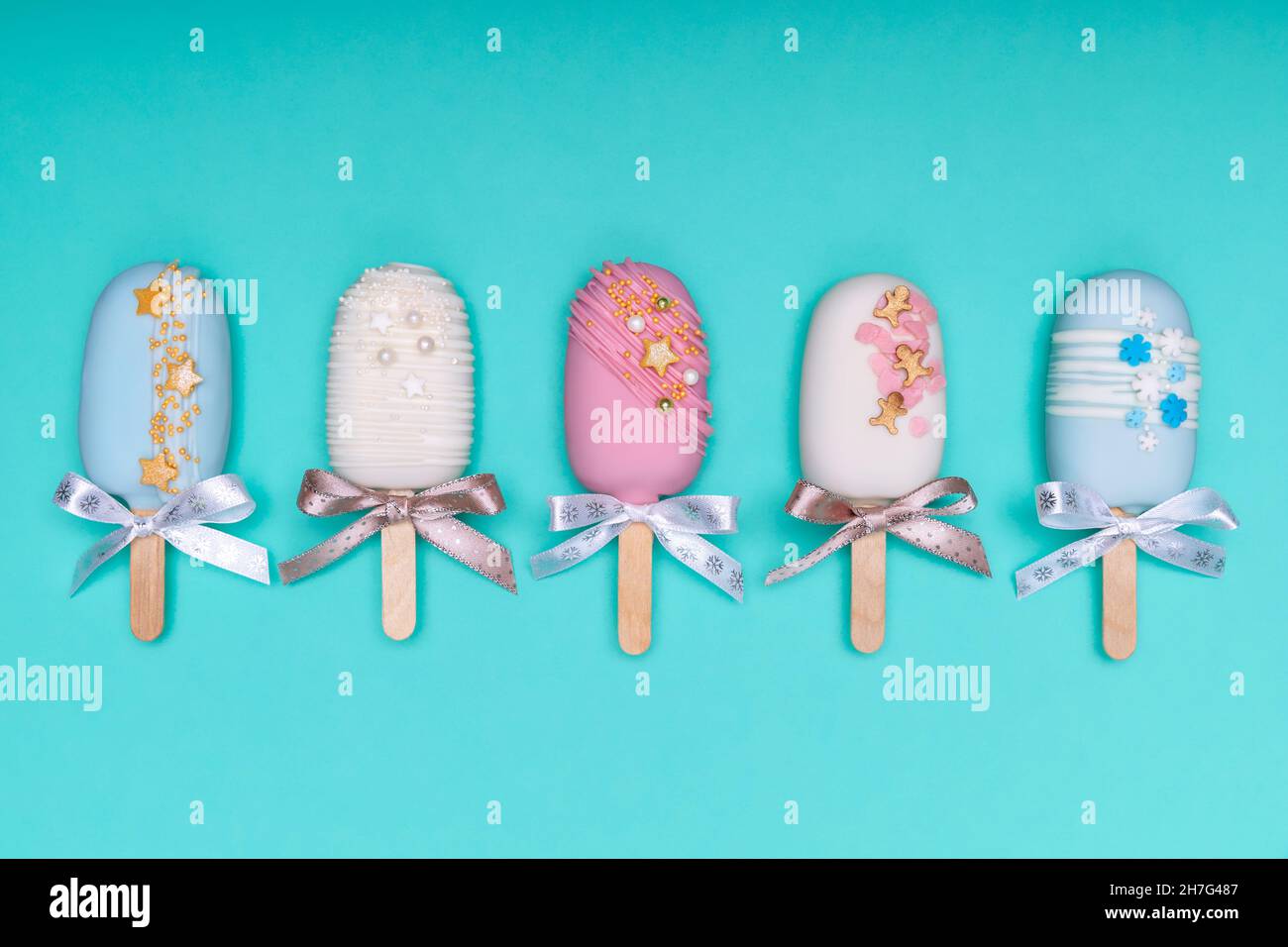 top view of decorated cake pops ice creams on turquoise background ...