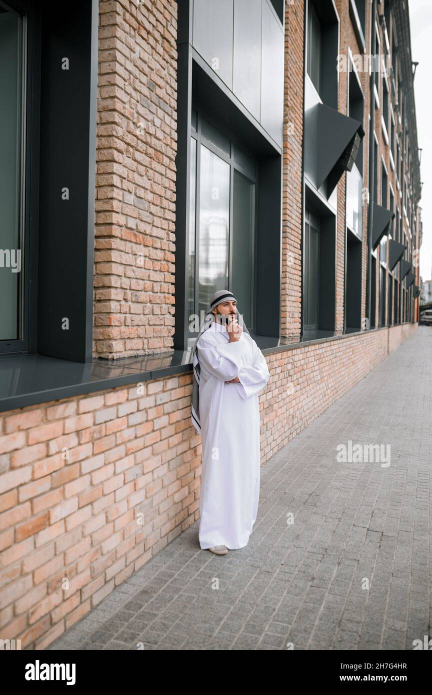 Man in traditional orient clothing in the city street Stock Photo - Alamy