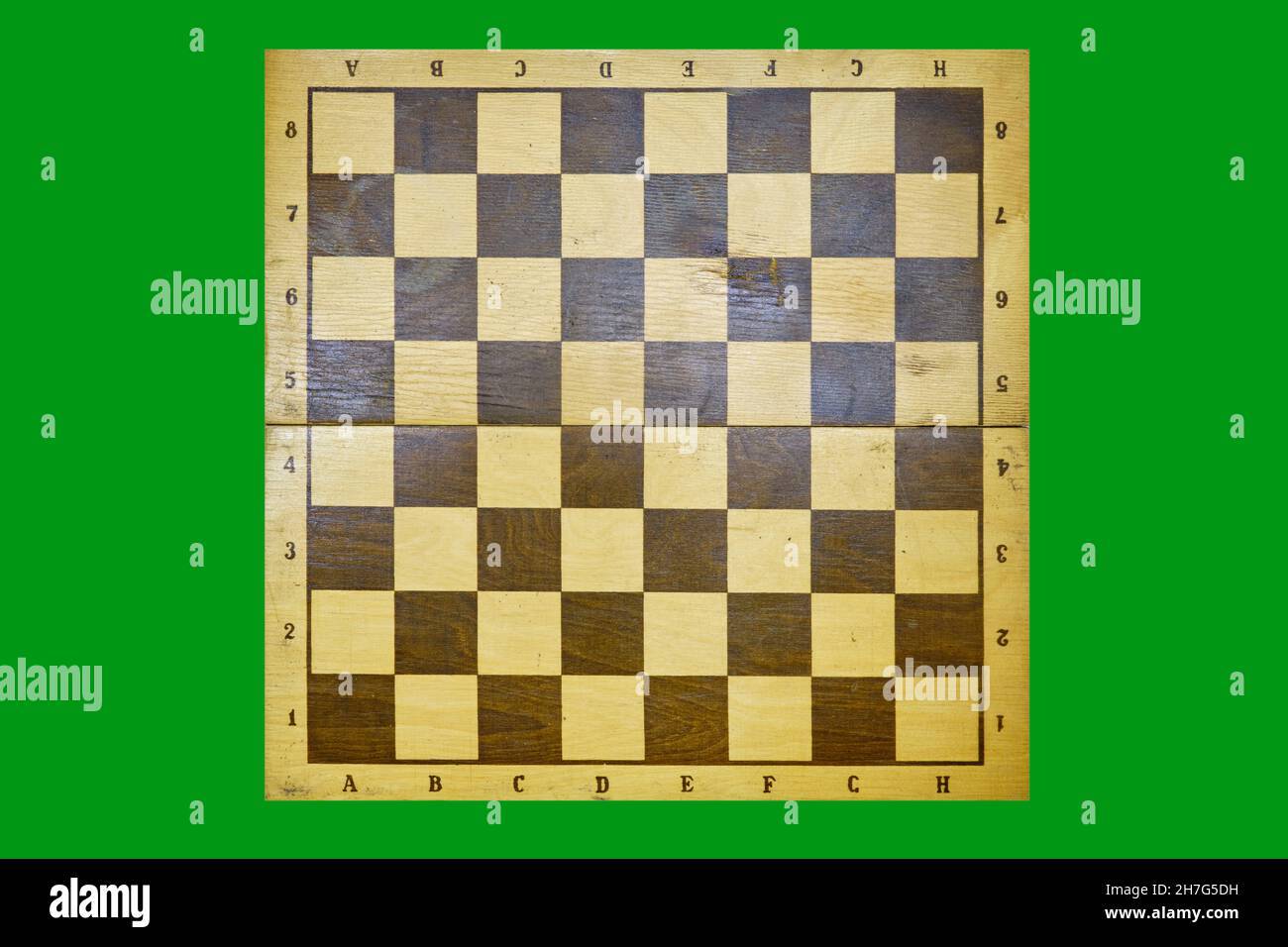 An empty vintage chessboard without retro pieces, isolated on a green ...