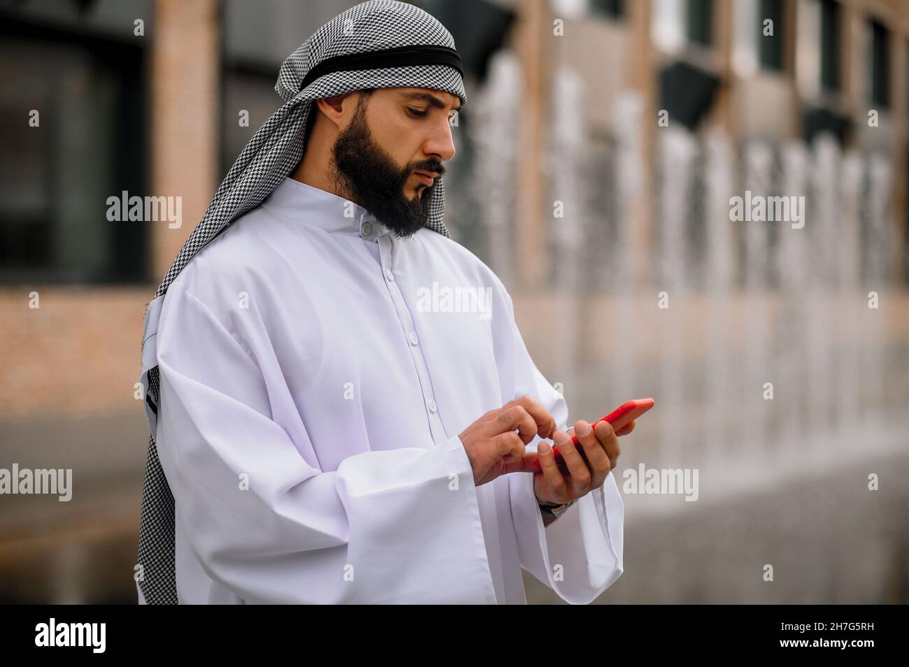 Arabian man with a smartphone in hands Stock Photo - Alamy