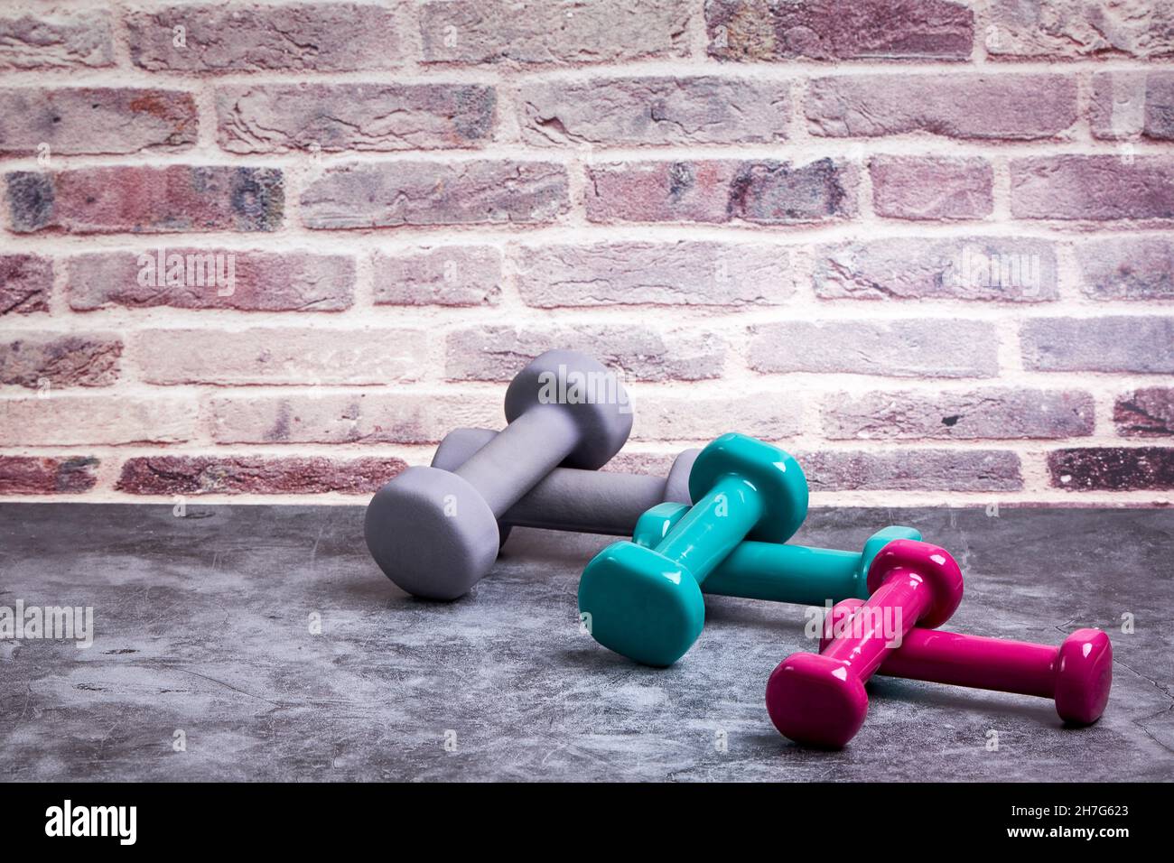 Variety of weights of different colors and weights on a gym floor ...