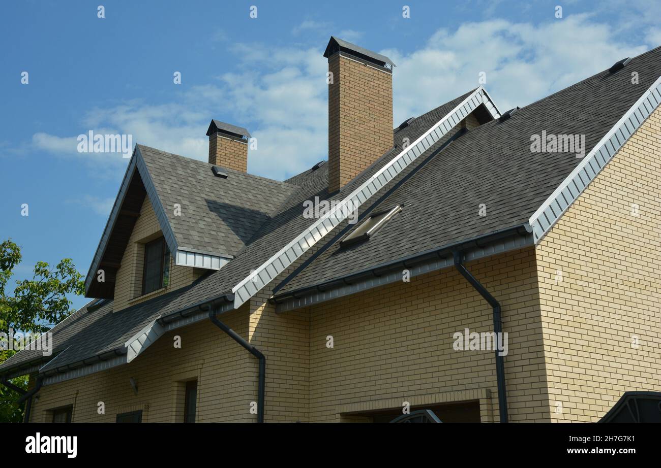 A close-up of a double complex roof of a brick house construction ...