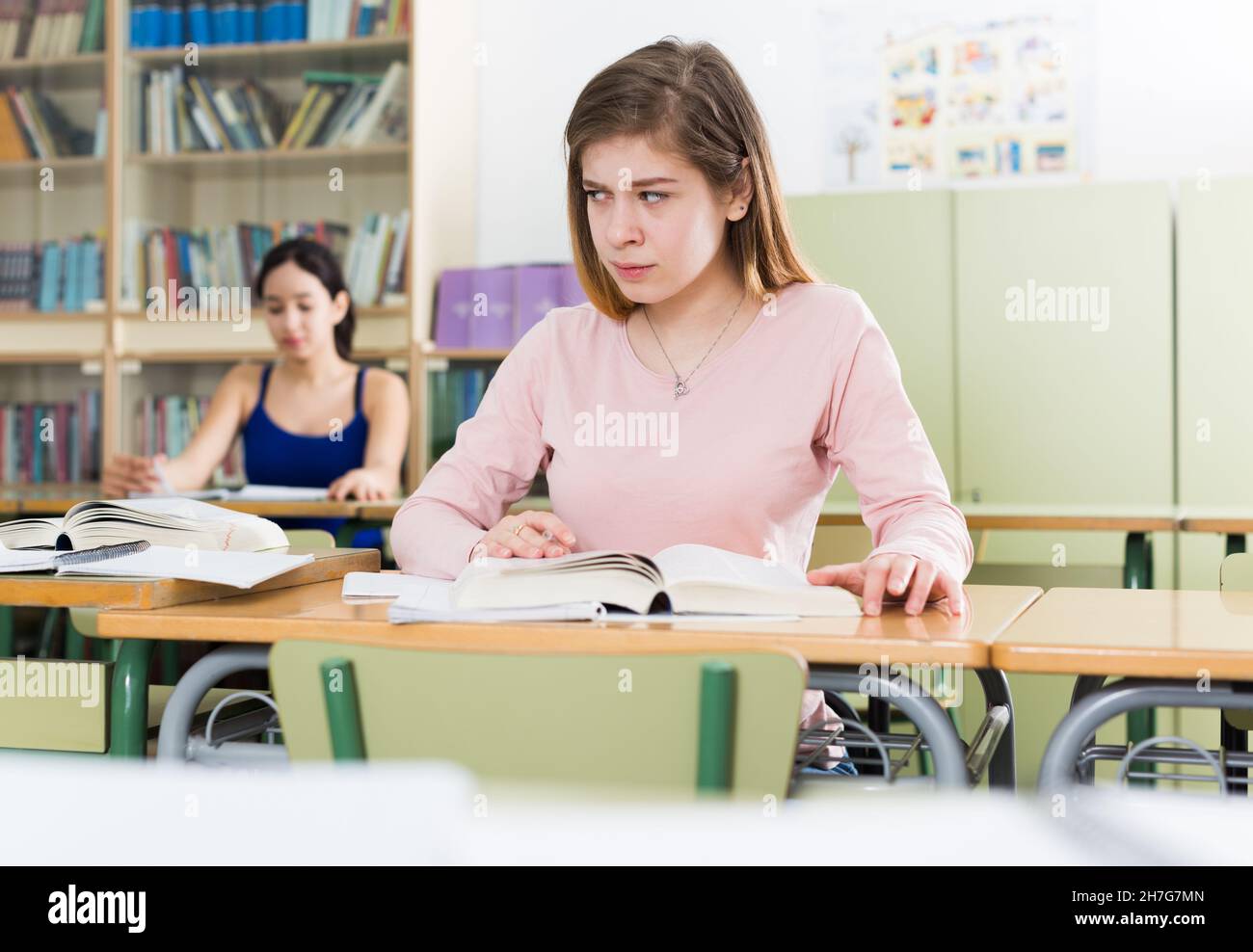 Girl is pondering about complicated task at the desk Stock Photo - Alamy