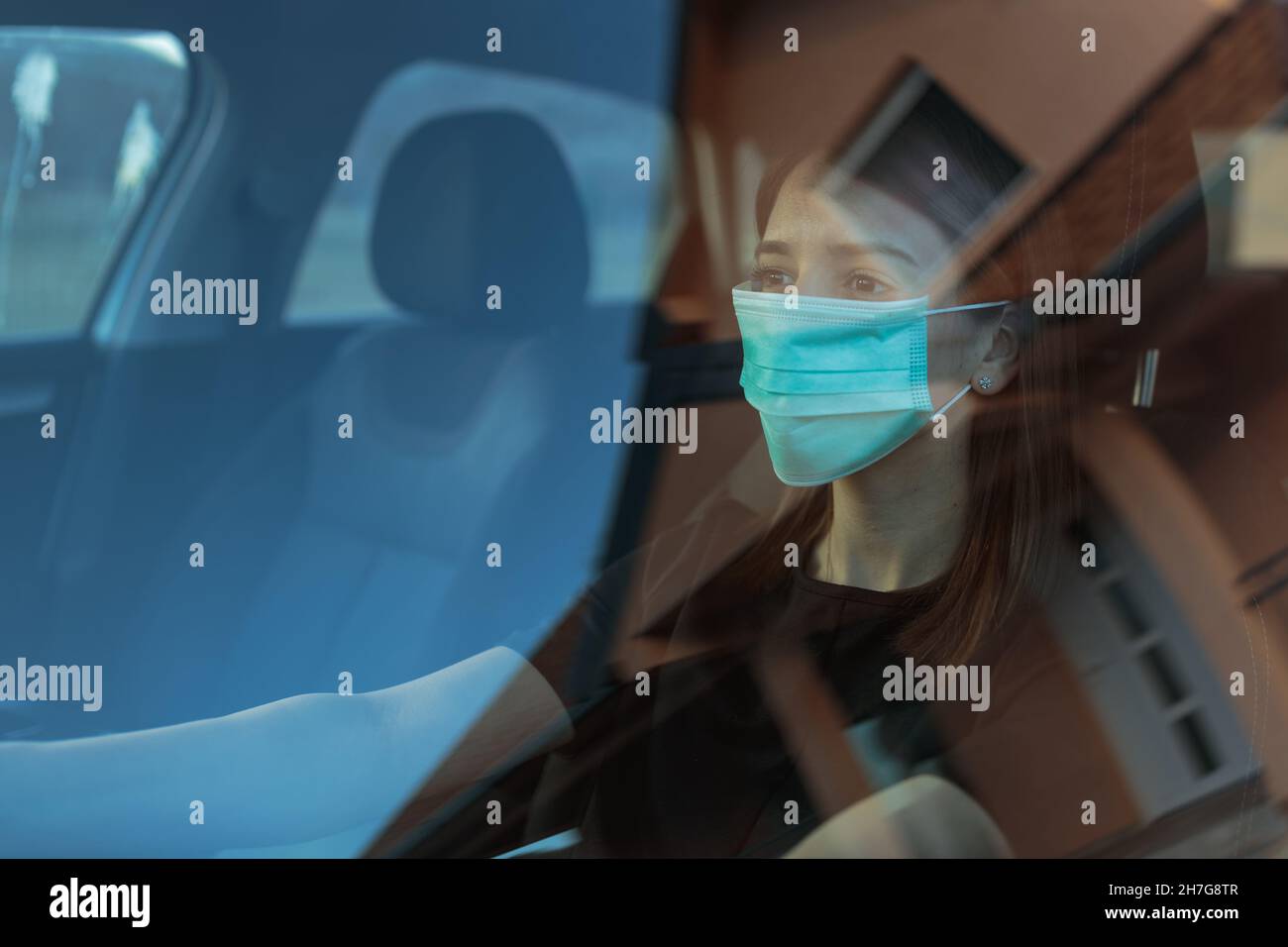 Caucasian female in a face mask driving a car Stock Photo - Alamy
