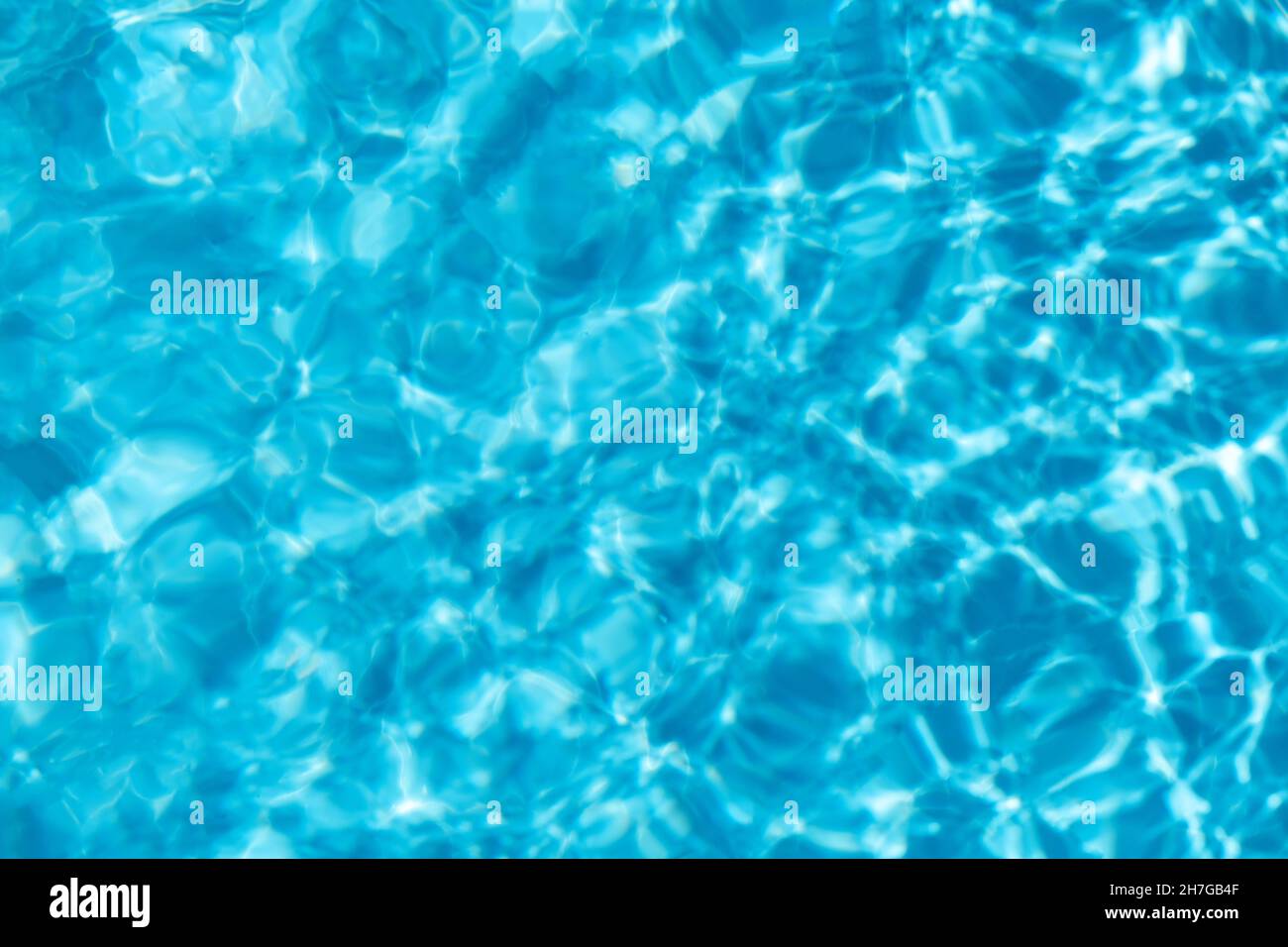 Summertime background with turquoise textured water in swimming pool ...