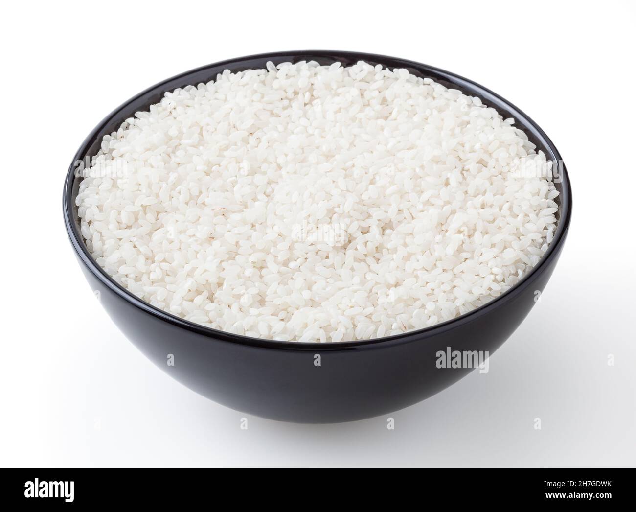 Uncooked round rice in black bowl isolated on white background with ...