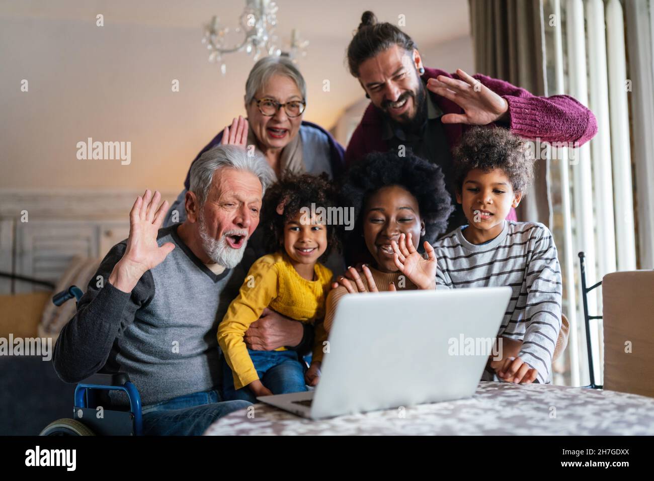 Extended multiethnic family together at home during video call. People ...