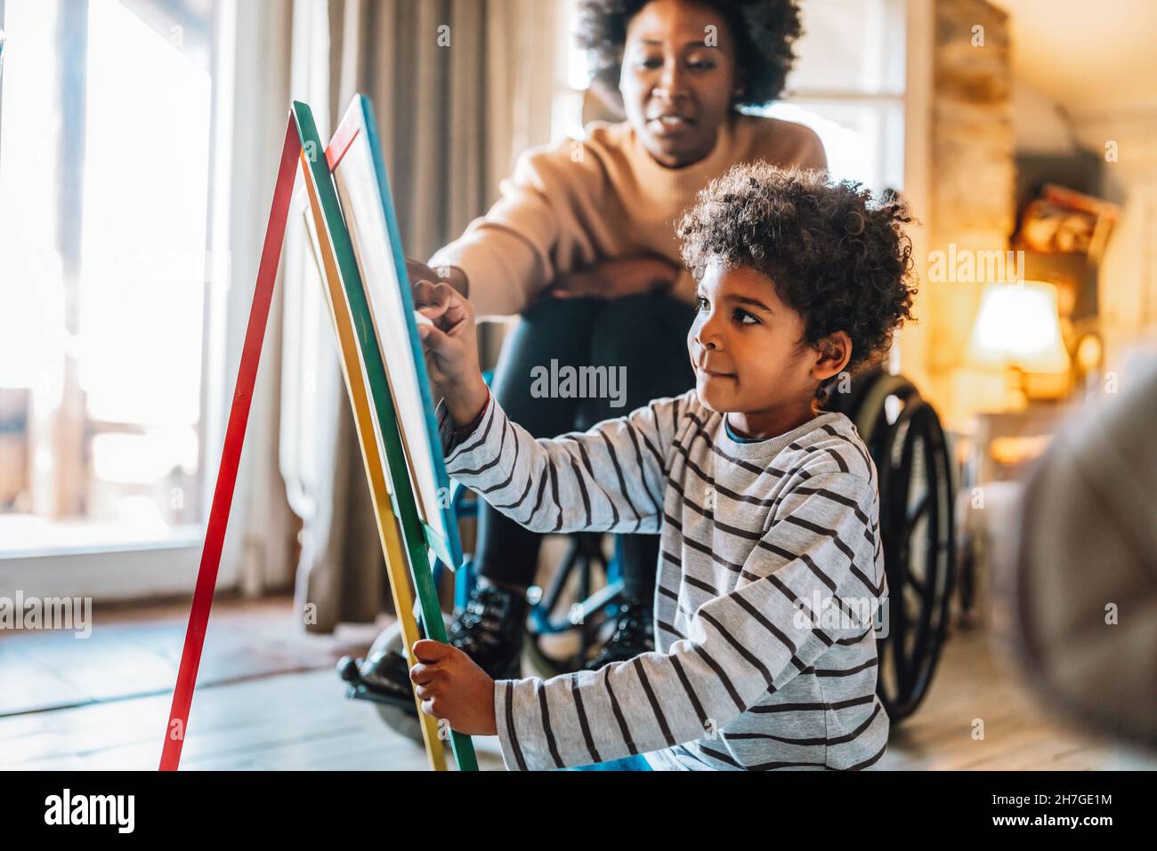 Happy child doing math exercises with her mother ot teacher together ...