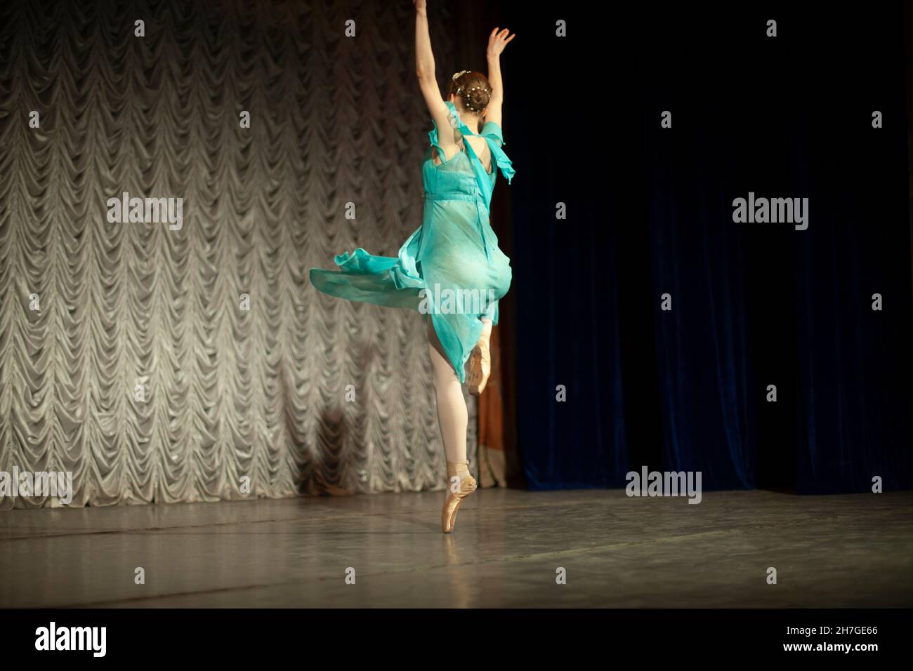 The ballerina dances on stage. Dance lesson in the hall. A girl in a ...