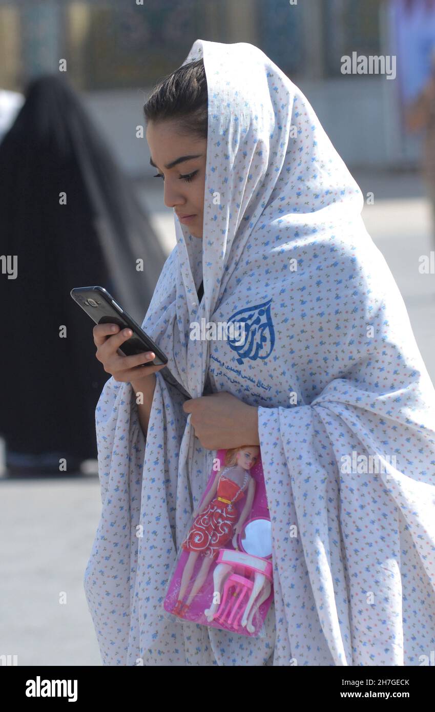 IRAN. SHIRAZ. YOUNG WOMAN WITH A VEIL, CELL PHONE AND SOME BABY DOLL ...