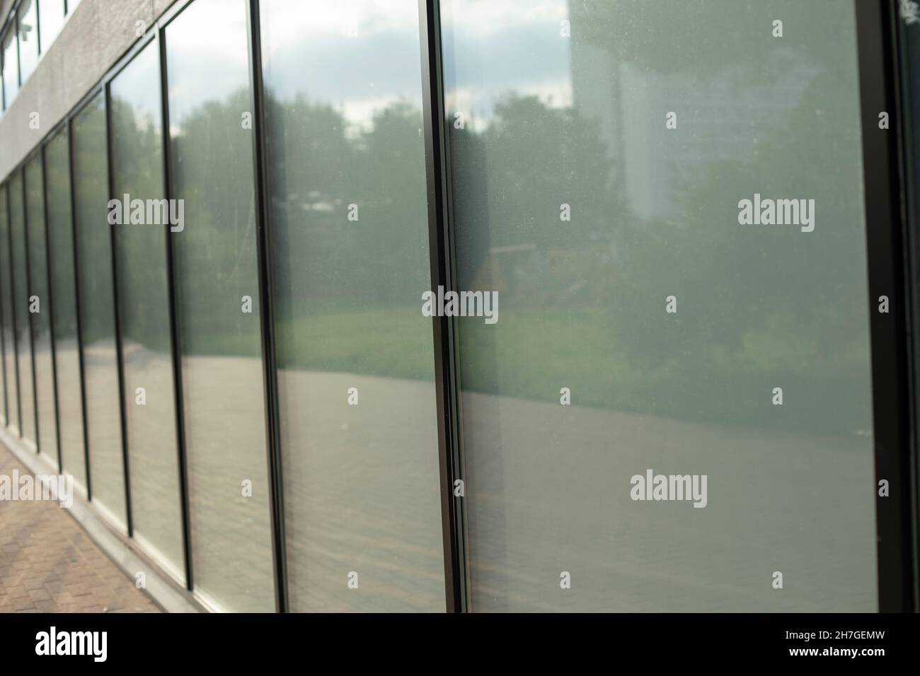Facade glass in a long house. A row of window frames. Shop window ...