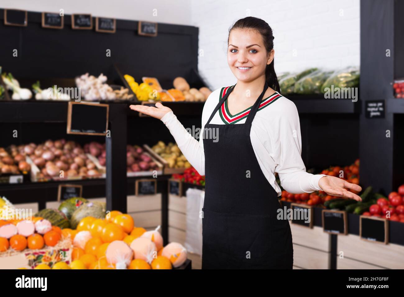 Woman assistant displaying fruits of grocery shop Stock Photo - Alamy