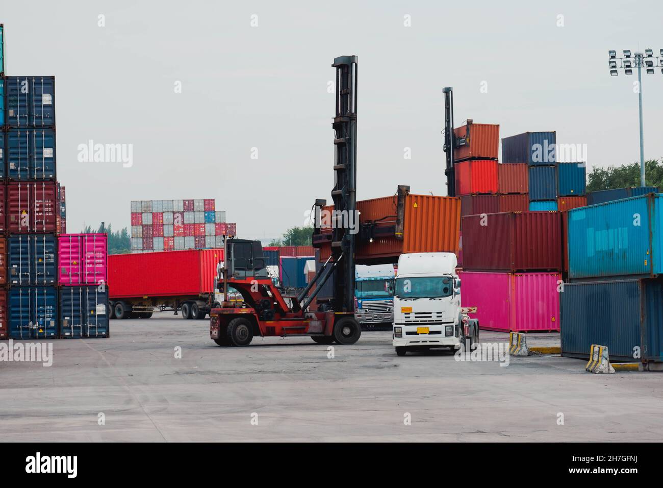 Forklift truck lifting cargo container in shipping yard or dock yard ...