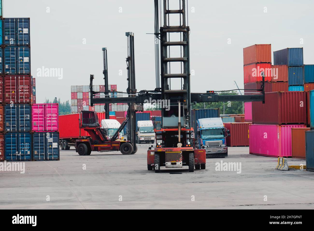 Forklift truck lifting cargo container in shipping yard or dock yard ...