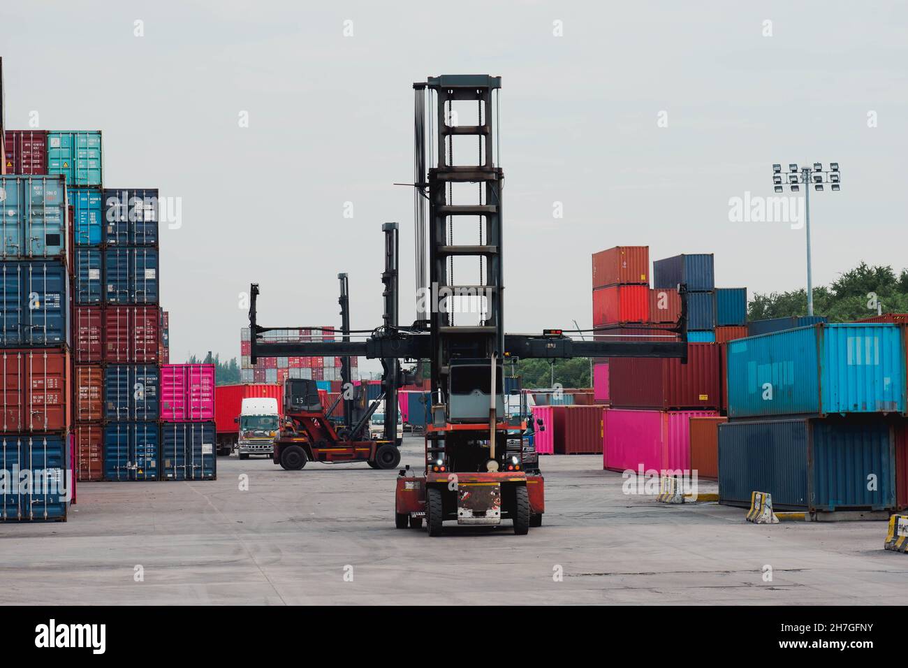Forklift truck lifting cargo container in shipping yard or dock yard ...