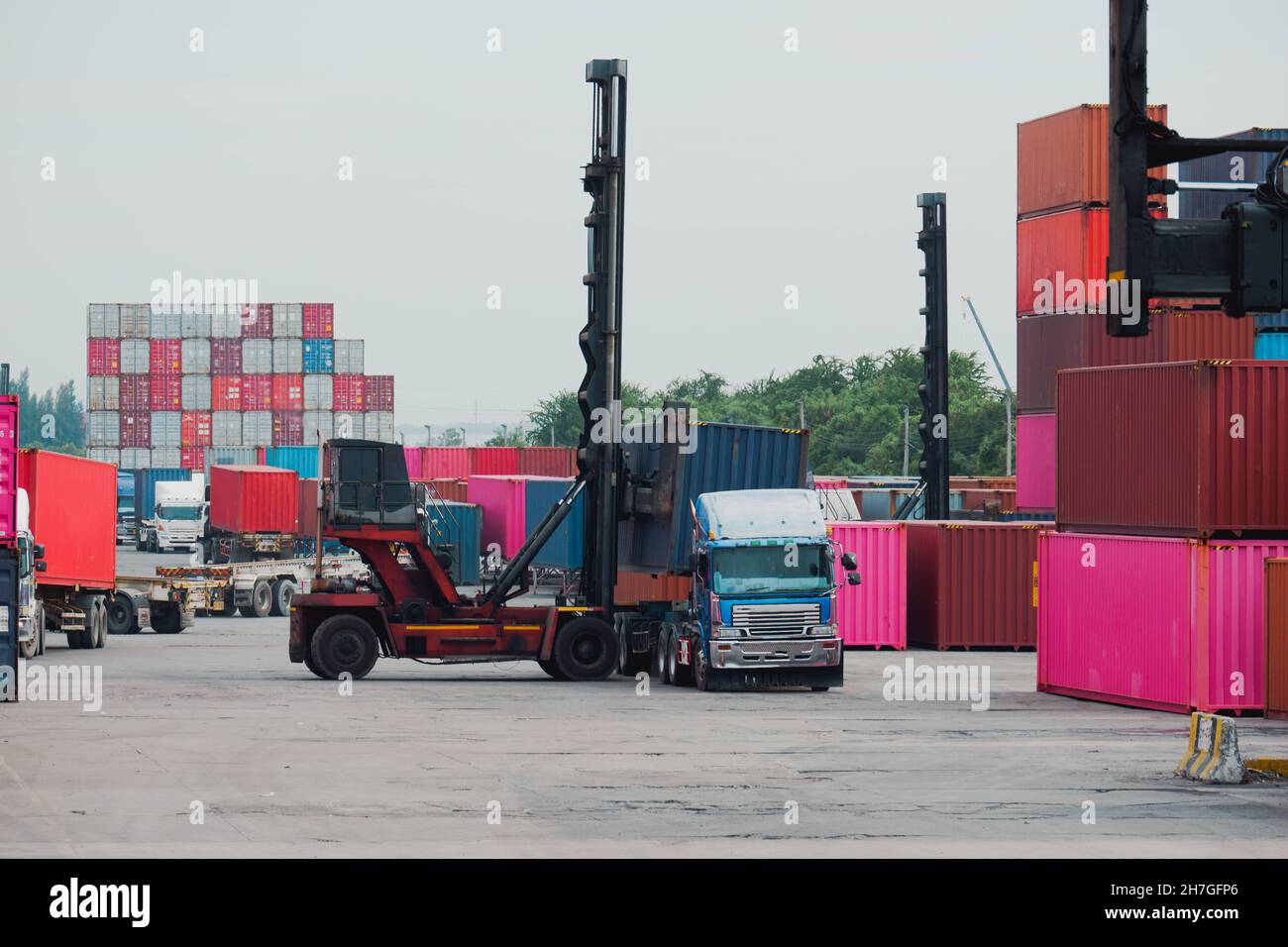 Forklift truck lifting cargo container in shipping yard or dock yard ...