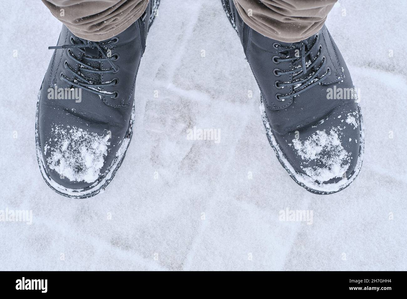 Black boots dusted with snow Stock Photo - Alamy