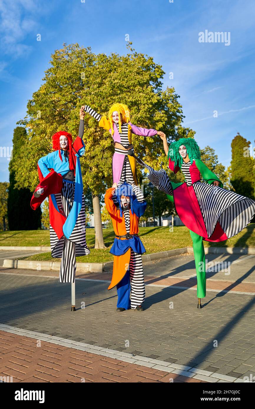 Full length group of happy clowns with painted faces in colorful ...