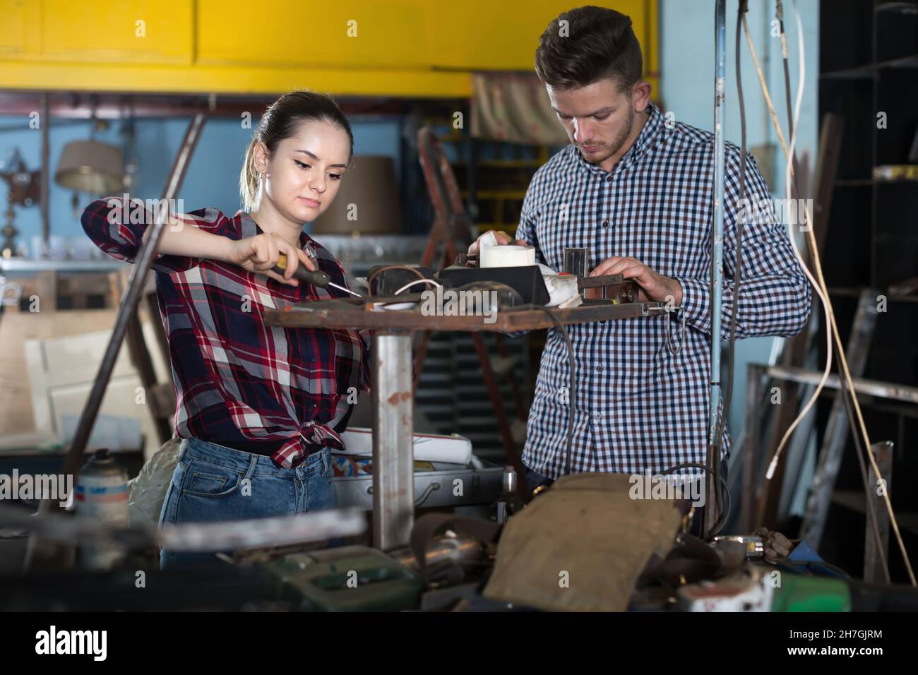 Two young professional masters working in workshop Stock Photo - Alamy