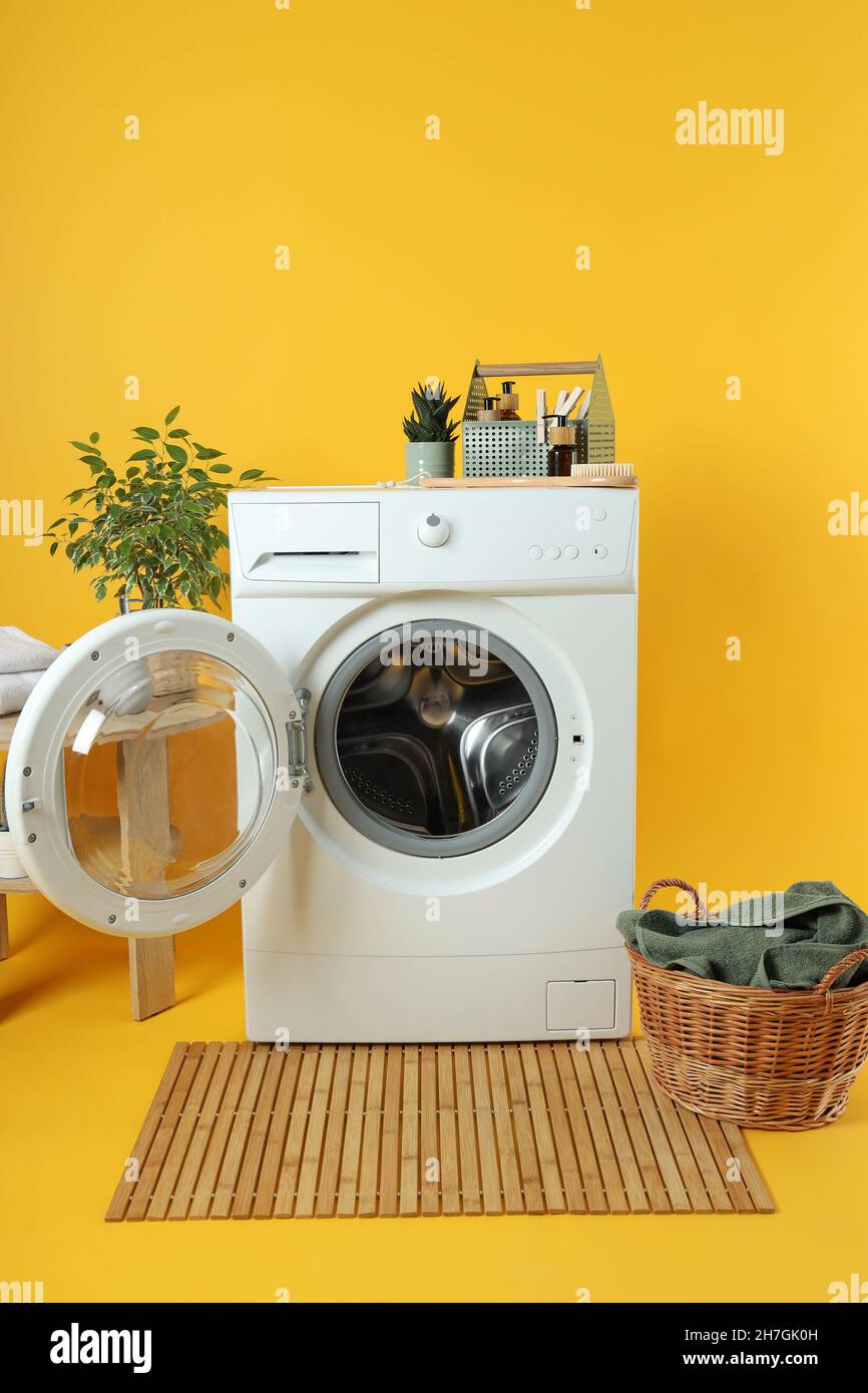 Concept of housework with washing machine on yellow background Stock ...