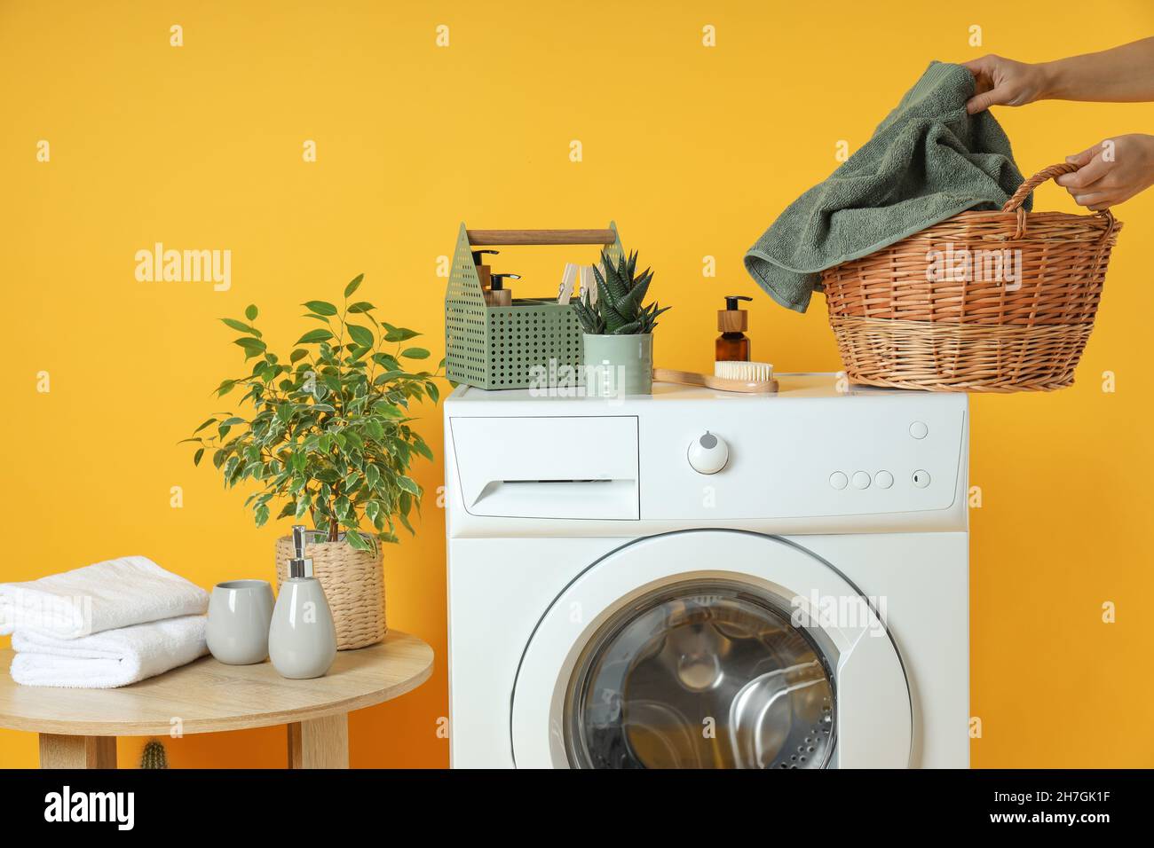 Concept of housework with washing machine on yellow background Stock ...