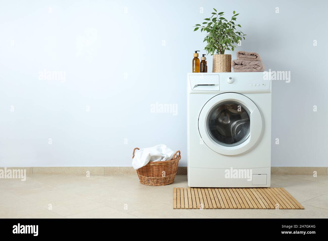 Concept of housework with washing machine against white wall Stock ...