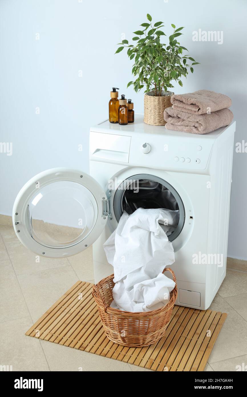 Concept of housework with washing machine against white wall Stock ...