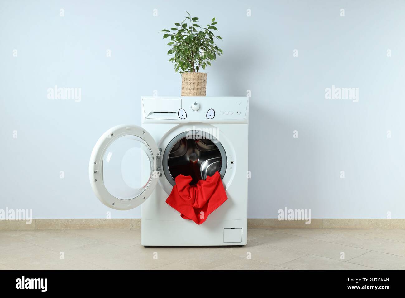 Concept of housework with washing machine against white wall Stock ...