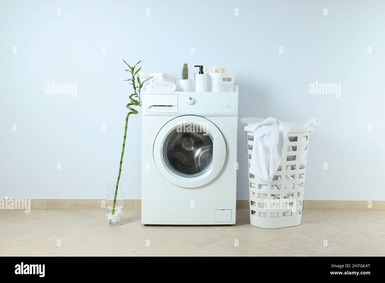 Concept of housework with washing machine against white wall Stock ...