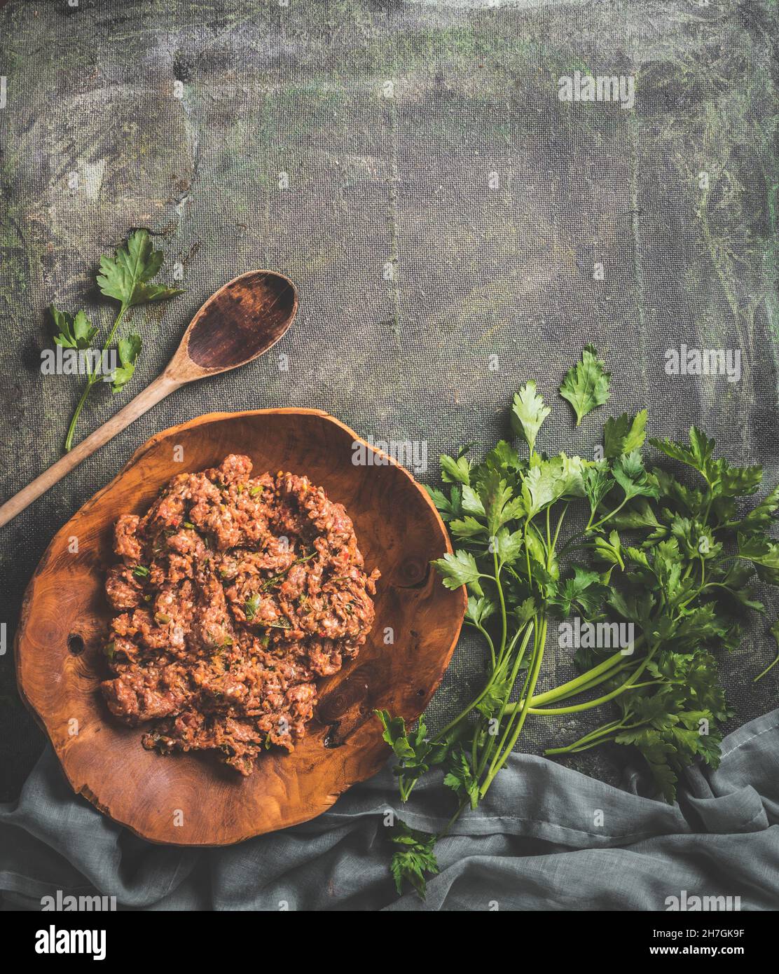 Food background with meat stuffing on dark table with herbs, wooden ...