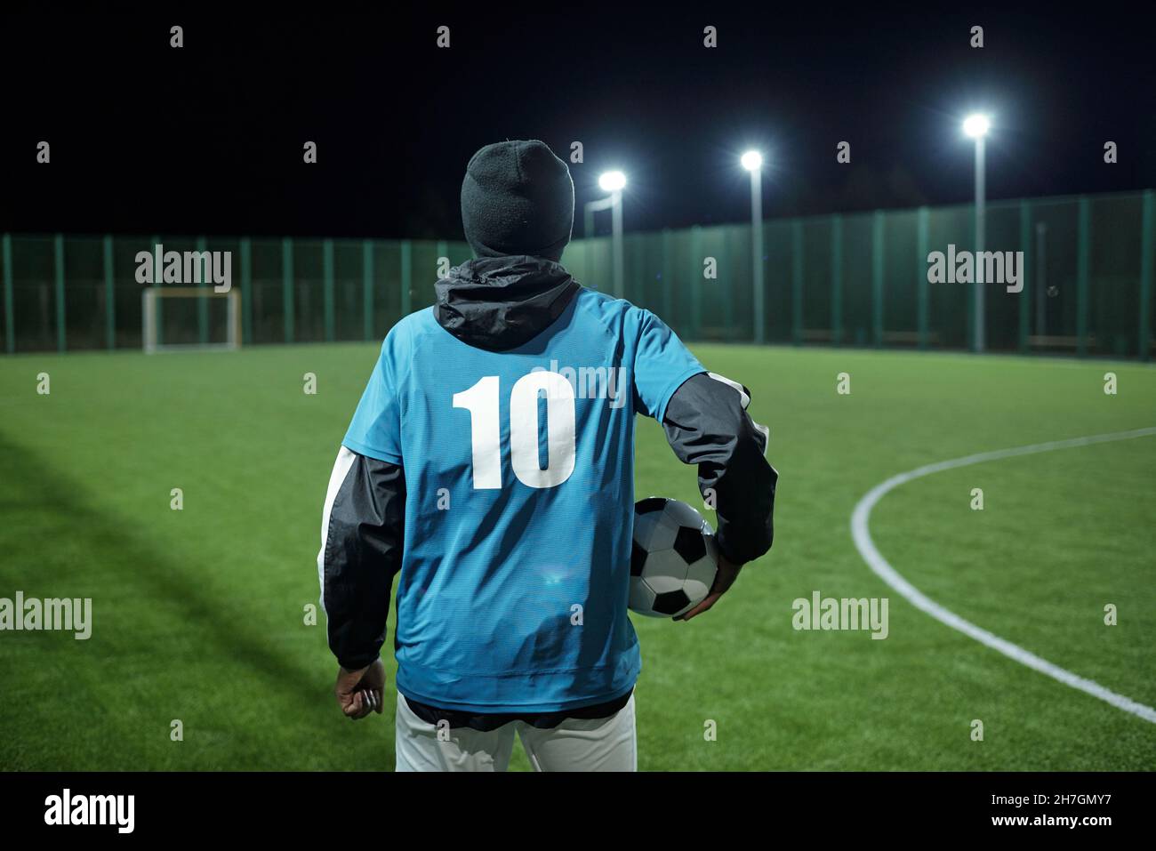 Rear view of contemporary professional soccer player with ball standing ...