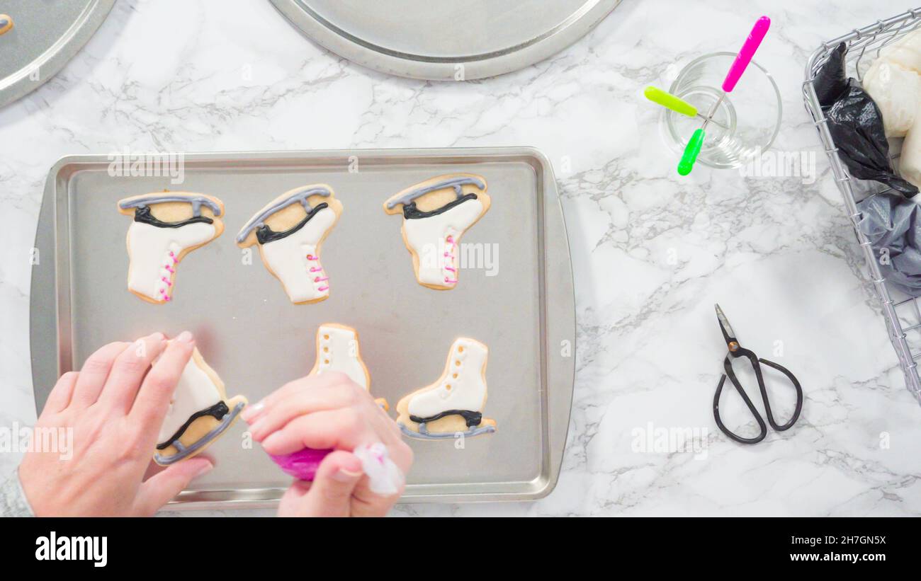 Flat lay. Icing figure skate shaped sugar cookies with royal icing ...