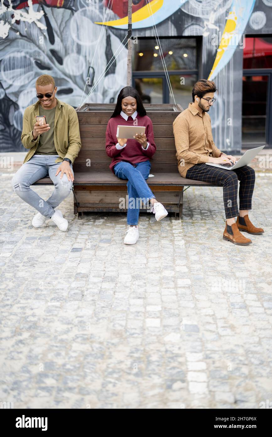 Young students using gadgets at university campus Stock Photo - Alamy