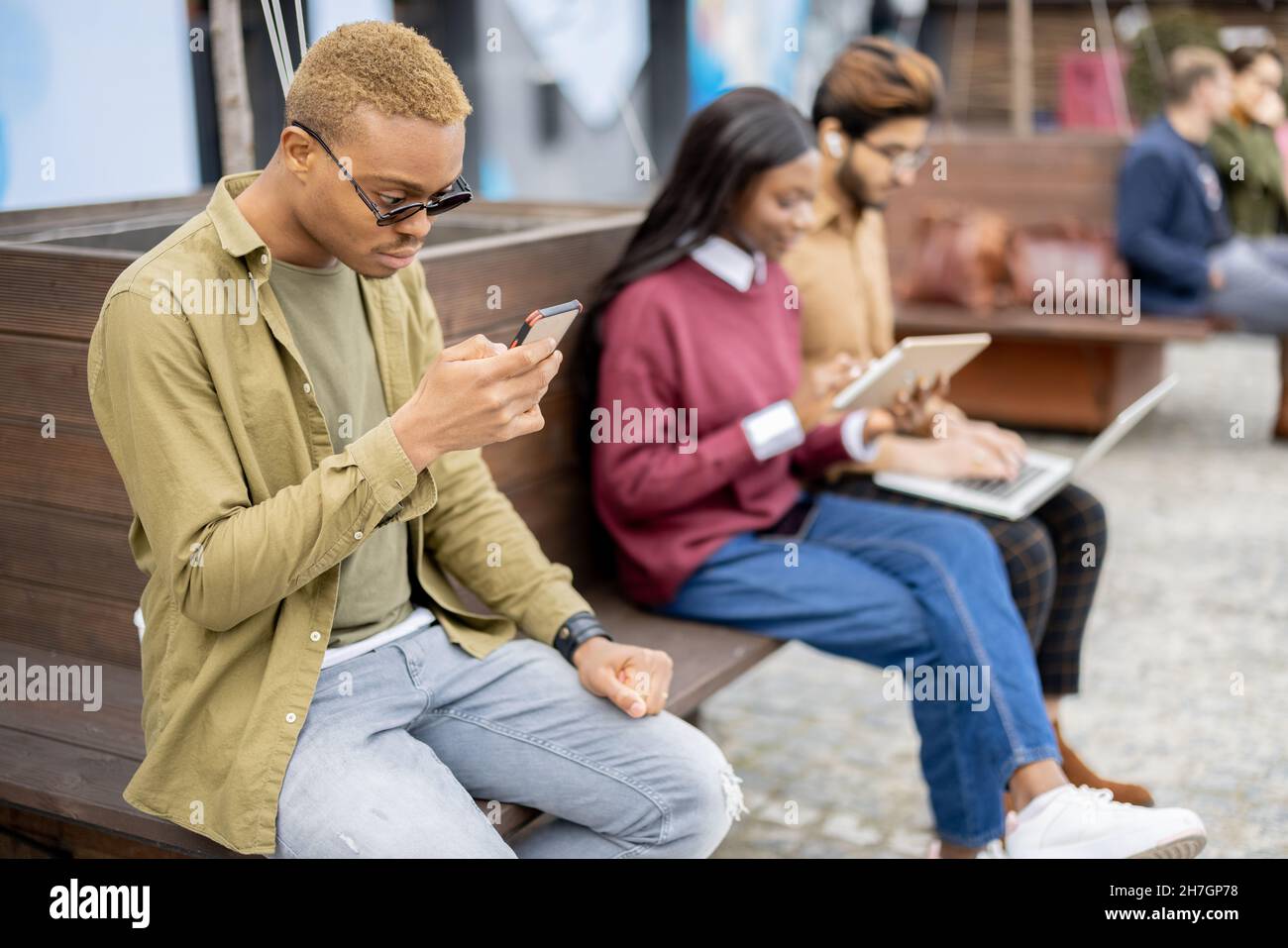 Young students using gadgets at university campus Stock Photo - Alamy