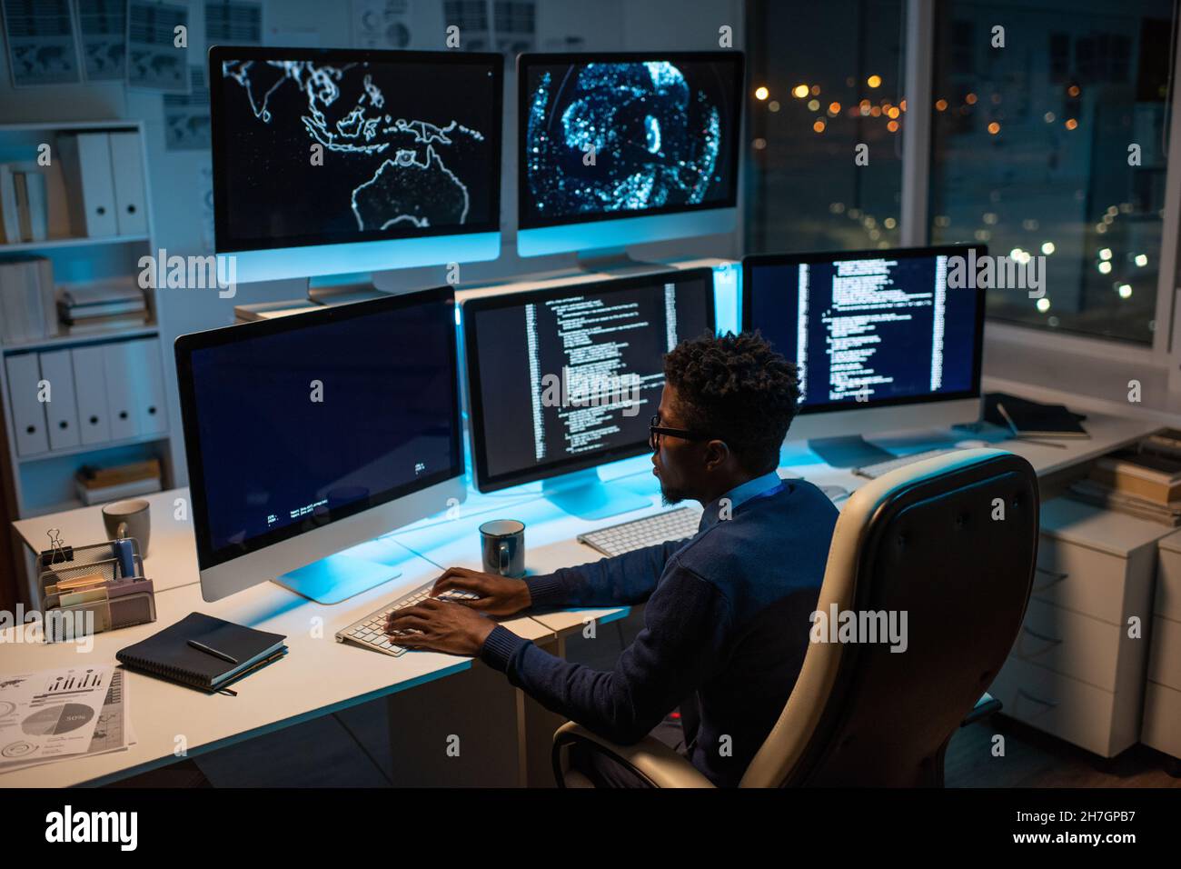 Young contemporary software developer working with decoded data while ...