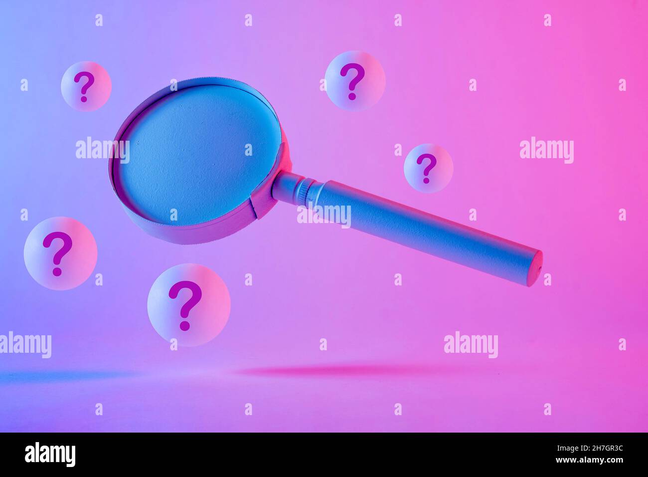 Studio close-up of an old magnifying glass floating between spheres ...