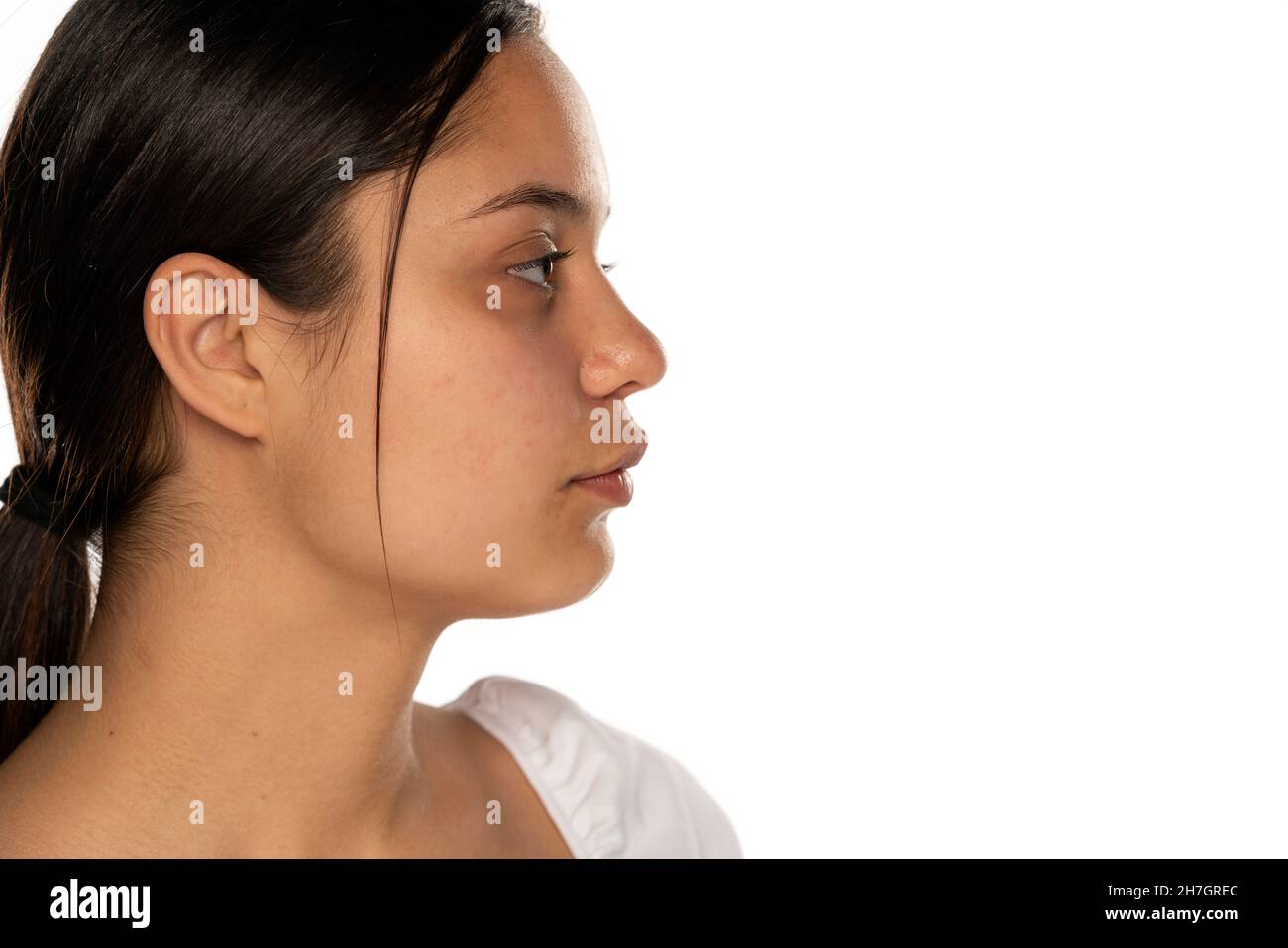 Profile of a young beautiful woman without makeup on a white background ...