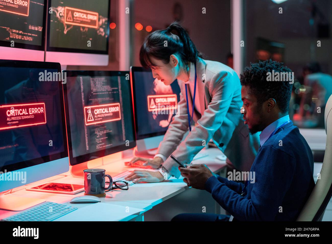 Two young intercultural programmers trying to solve technical problem ...