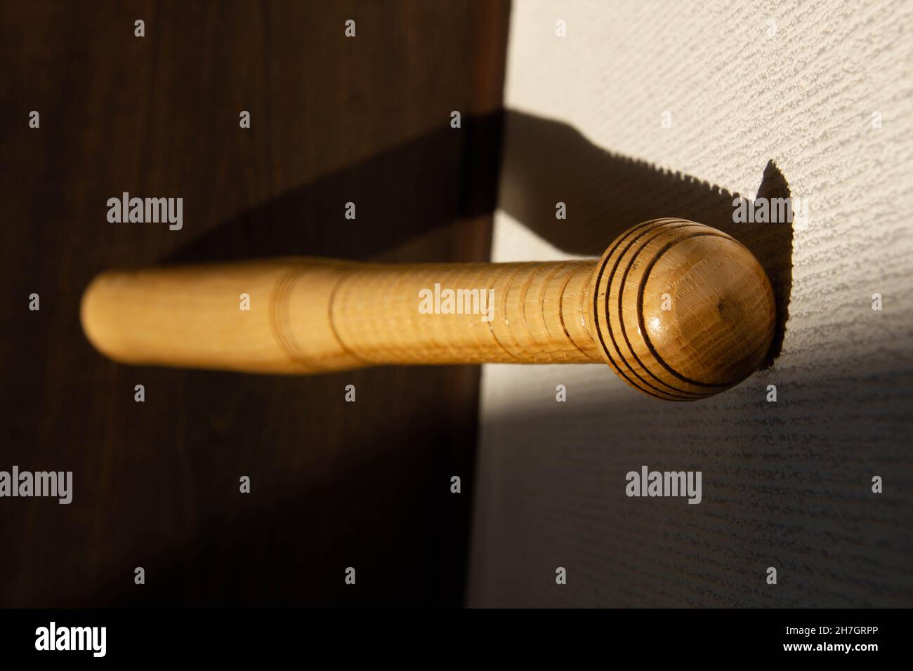 A baseball bat stands against the wall. Beautiful shadow of the sun ...